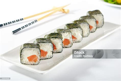 훈제 연어로 만든 필라델피아 스시 롤 노리 해초와 함께 바깥쪽에 연어와 크림 치즈를 넣은 마키 초밥 흰색 테이블에 나무 젓가락흰색 접시 0명에 대한 스톡 사진 및 기타