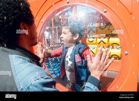 Young Latino Father And Son Happy Playing Among Plastic Games In Public Park In Buenos Aires