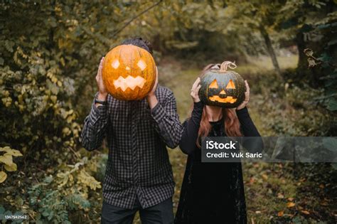 머리 앞에서 조각된 호박을 들고 있는 위장한 남자와 여자 할로윈에 대한 스톡 사진 및 기타 이미지 할로윈 호박 등불 호박