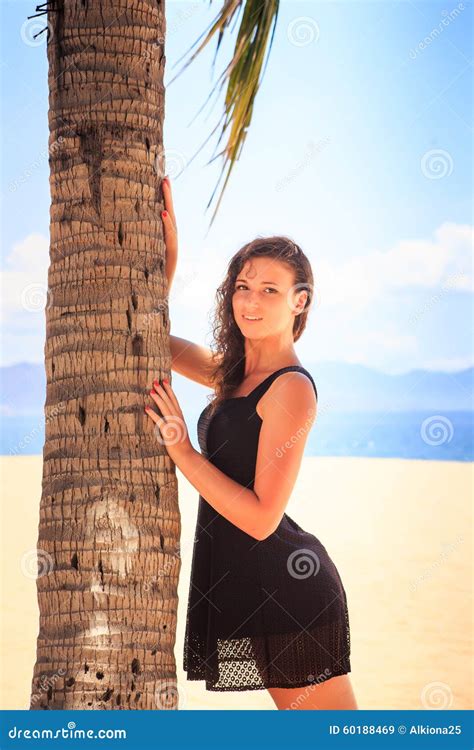 La Fille Mince Dans La Robe Noire De Dentelle Touche Nu Pieds La Paume