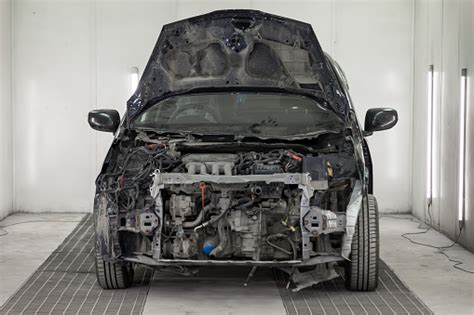 차량의 바디 페인트 작업장에서 수리를 기다리고있는 열린 후드와 함께 몸의 완전히 깨진 전면과 심각한 사고 후 검은 자동차 자동차 서비스 산업 0명에 대한 스톡 사진 및 기타