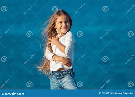 Прелестная счастливая усмехаясь маленькая девочка на пляже Стоковое Фото изображение