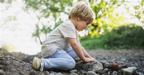 자연에서 바위와 진흙을 가지고 노는 행복한 작은 소년의 측면 보기 사진 Unsplash의 봄 이미지