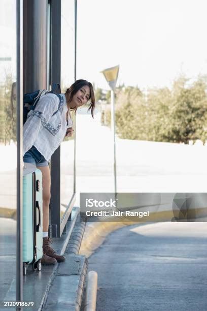 20대 여성 여행하며 역에서 교통편을 기다리며 여행 가방을 들고 서 있는 젊은 여성의 카피 공간이 있는 세로 사진 20 29세에 대한 스톡 사진 및 기타 이미지 Istock