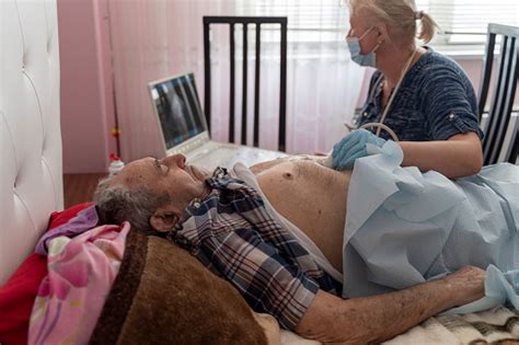 간호사 의료 기술자 휴대용 초음파 기계를 사용하여 노인 97 세 남성 환자를위한 가정에서 초음파 내부 기관의 건강 평가를