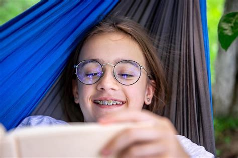 Ragazza Carina Che Legge Un Libro Su Unamaca In Giardino Foto Gratis