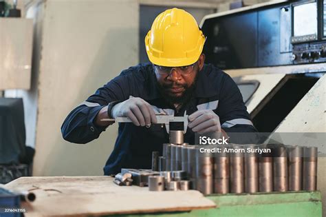 안전 유니폼 안경 및 안전모를 착용하고 산업 공장에서 Cnc 기계의 고품질 부품을 검사하는 남성 엔지니어 작업자 작업장에서 남성 기술자 수리 강철 선반 기계 40 44세에