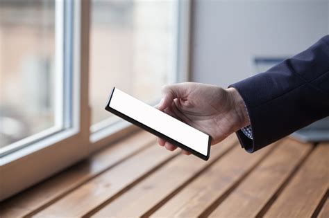 빈 화면 휴대 전화의 모형 사진 홈 오피스에서 스마트 폰을 사용하여 문자 메시지를 들고있는 남성 텍스트 광고를위한 흰색 빈 공간