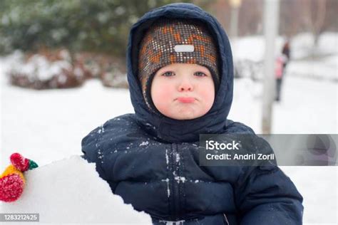 어린 아이는 겨울에 야외에서 눈이나 얼음 조각을 가지고 노는다 겨울의 어린이 활동 겨울에 대한 스톡 사진 및 기타 이미지