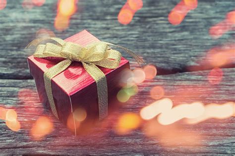 오래된 나무 테이블 텍스처 추상적 인 배경에 화려한 보케 태양 빛과 빨간색 선물 상자 이중 노출을 닫습니다 휴일 현재 개념의 공간을 복사합니다 빈티지 톤 필터 효과 색상