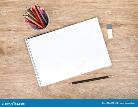 Чистый лист бумаги и красочные карандаши на деревянном столе Стоковое Фото изображение