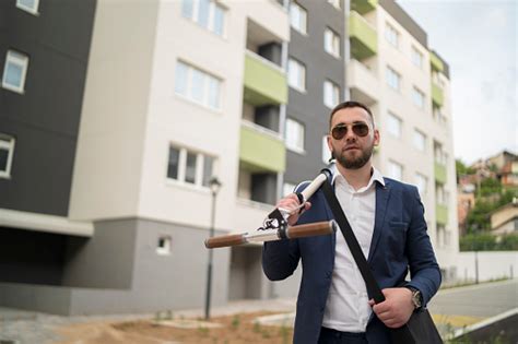 도시에서 야외에서 서있는 동안 그의 손에 스쿠터를 들고 남자 개념에 대한 스톡 사진 및 기타 이미지 개념 거리 계절