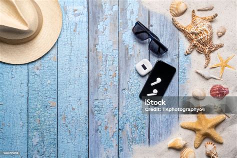 여름 해변 휴가 컨셉으로 자유로운 텍스트 공간을 즐길 수 있다 평면도 남자 밀짚모자 스마트폰 무선 이어폰 선글라스 큰 바다 별과 조개껍데기 다양한 조개껍데기와 고운 해변