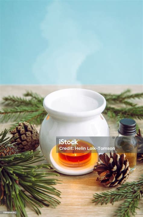 소나무 가문비 나무 에센셜 오일 병과 나무와 파란색 배경에 장식 나무 가지와 흰색 세라믹 촛불 아로마 오일 램프 0명에 대한 스톡 사진 및 기타 이미지 Istock
