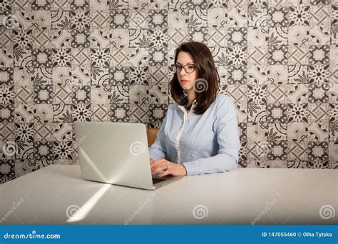 Young Businesswoman Wearing Glasses Sitting At Her Desk At The Computer Profile View In The