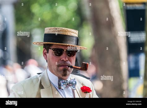 a chap wears a traditional straw boater and smokes a pipe at the chap