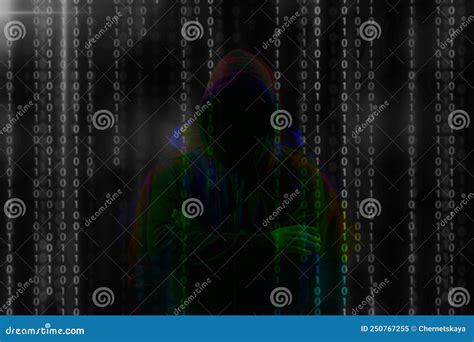 Silhouette Of Anonymous Hacker And Digital Binary Code On Dark