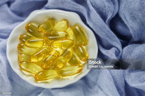 밝은 배경에 흰색 접시에 오메가 3 생선 기름 캡슐 의료 식품 용품입니다 불포화 지방산의 산입니다 건강 한 식 생활의 개념입니다