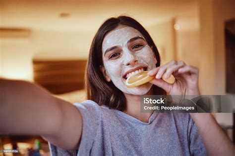 셀카 초상화 침실에서 스킨케어 미용 몸단장 중에 오렌지를 먹는 여자 행복하고 미소 짓는 여자 얼굴 비타민 C 및 소녀 인플루언서는 집에서 과일 페이셜 마스크 또는 디톡스