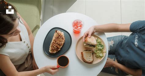 한 남자와 한 여자가 음식이 담긴 접시가 있는 식탁에 앉아 있다 사진 Unsplash의 무료 커피 이미지