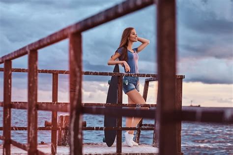 Retrato De Uma Garota Sensual Feliz Posando Com Skate Em Um Cais Antigo Est Desfrutando De Um