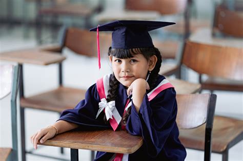 학업 가운과 졸업 모자를 쓴 쾌활한 아이 졸업생이 교실에서 졸업을 축하합니다 6 7 살에 대한 스톡 사진 및 기타 이미지 6 7 살 고등학교 이하 공부 Istock