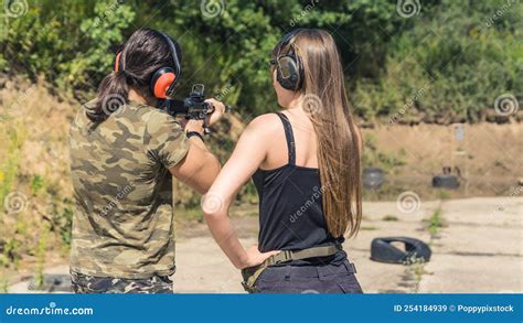 White Woman And Man Wearing Safety Gear At Outdoor Shooting Range