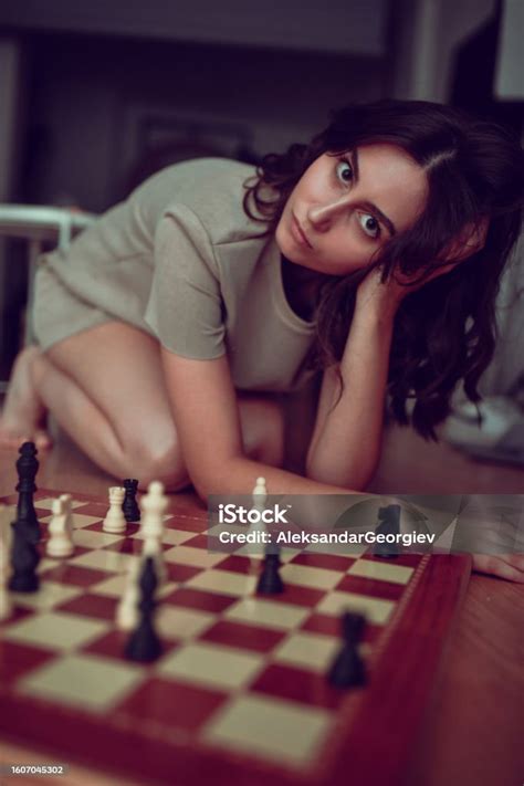 Portrait Of Beautiful Female Chess Player Lying On The Ground While