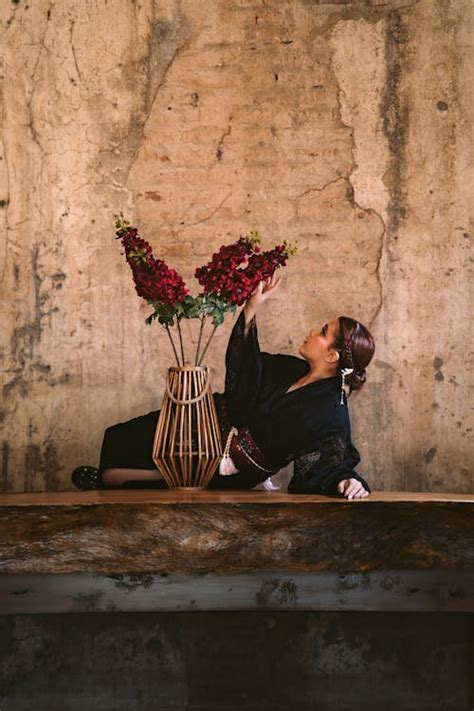 붉은 꽃을 든 여성의 우아한 초상화 · 무료 스톡 사진