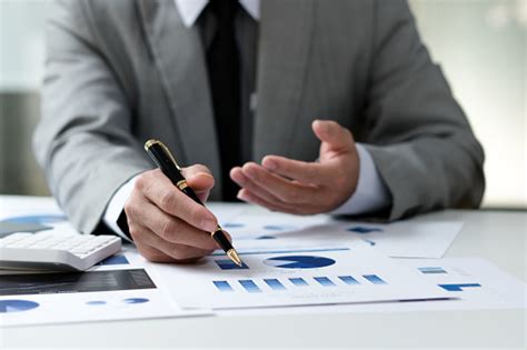 사업가 펜 포인팅 그래프 차트이달의 그래프 차트와 다음 달 품질 향상을 위한 계획에 계산기를 사용합니다 개발에 대한 스톡 사진 및 기타 이미지 Istock