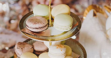 아름다운 빈티지 스탠드에 맛있는 다채로운 마카롱이 있고 금색과 은색 색종이가 있는 테이블에 금 장식품이 있습니다 고급 케이터링 신부 암탉 또는 베이비 샤워 프랑스