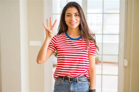 젊은 아름 다운 여자를 입고 캐주얼 T 셔츠를 표시 하 고 손가락으로 가리키는 4 숫자와 함께 웃는 자신감과 행복 T 셔츠에 대한 스톡 사진 및 기타 이미지 Istock