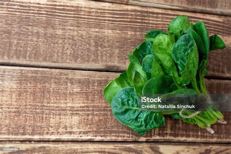 깨끗한 음식 개념 잘 익은 육즙의 잎은 나무 배경에 갓 수확 된 유기농 시금치 채소 건강한 해독 봄 여름 다이어트 비건 생 식품 공간을 복사합니다 건강관리와 의술에 대한