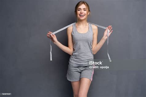 여자와 줄자 측정 젊고 스포티하며 몸에 잘 맞고 아름다운 소녀로 측정 테이프를 착용했습니다 가냘픈에 대한 스톡 사진 및 기타