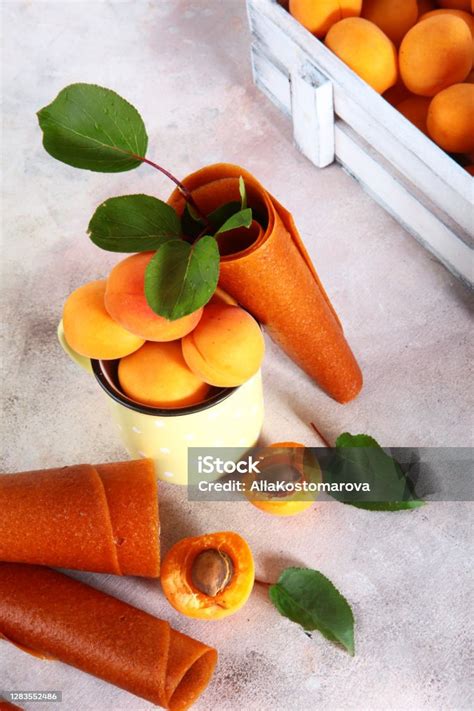 노란 원을 그리며 살구와 살구가 하얀 배경의 튜브에 굴러 들어갔다 나무 상자에 과일 천연 및 식이 제품 저칼로리 음식 이나 간식 세로 사진 운동 선수를위한 음식 건강한