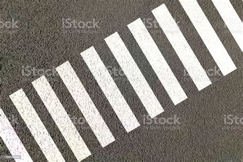 바쁜 교통 고속도로에서 횡단 보행자를위해 도로에 그려진 줄무늬 흰색과 검은 색 선으로 만든 얼룩말 횡단 도로에 대한 스톡 사진
