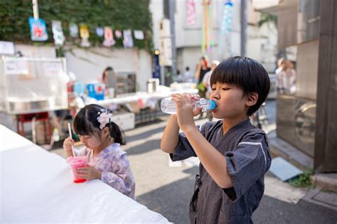 유카타 금베이의 여동생과 남동생은 일본 전통 여름 축제를 즐기며 탄산음료와 카키고리를 마신다 Matsuri에 대한 스톡 사진 및