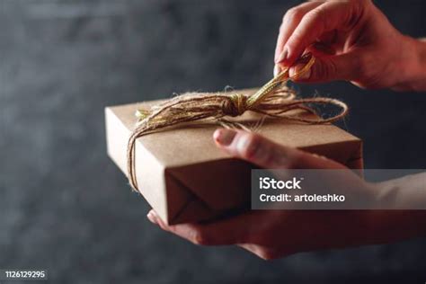 선물 상자를 들고 손을 어두운 나무 배경에 Kraft 종이에 포장 발렌타인의와 여자의 날 크리스마스 카드 기념일에 대한 스톡 사진 및 기타 이미지 Istock