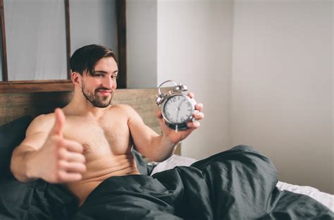 Premium Photo Guy Is Waking Up Man Holding An Alarm Clock Bearded Naked Man Showing Thumbs Up