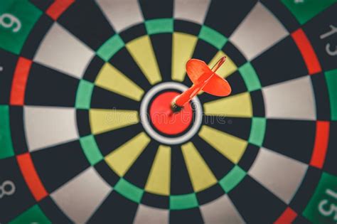Bullseye Or Bulls Eye Target Or Dartboard Has Red Dart Arrow Throw Hitting The Center Of A