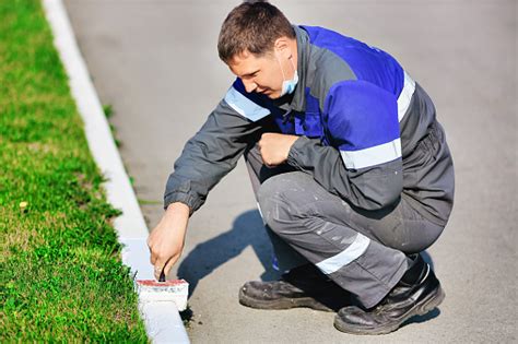 바지의 작업자가 여름날에 흰색 페인트로 연석을 그립니다 도시 서비스 영토 개선 거리에 대한 스톡 사진 및 기타 이미지 거리 공사장 인부 남자 Istock