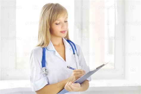 Фотография на тему Женщина врач держит блокнот Pressfoto