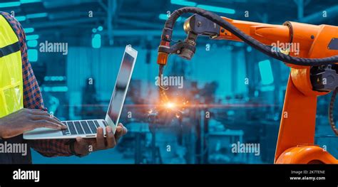 Engineer Worker Using Laptop Computer Program Control Robotic Arm Welding With Ai Automation