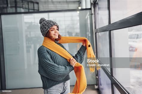 노란 스카프와 실내에 서 있는 따뜻한 옷을 입은 아름다운 쾌활한 소녀 16 17 살에 대한 스톡 사진 및 기타 이미지 16 17 살 공항 긍정적인 감정 표현 Istock