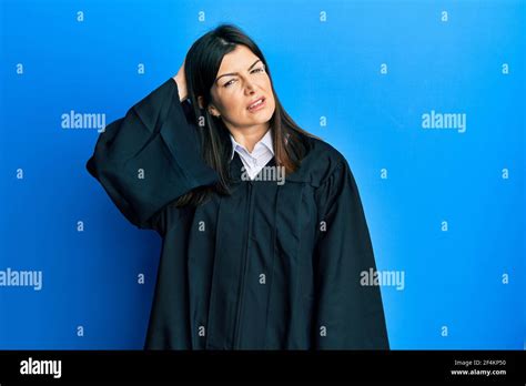 Young Hispanic Woman Wearing Judge Uniform Confuse And Wonder About
