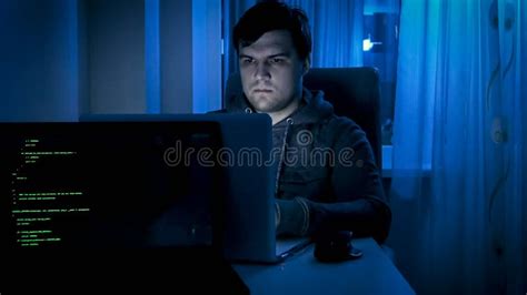 Portrait Of Male Programmer Or Hacker Working On Computer At Night