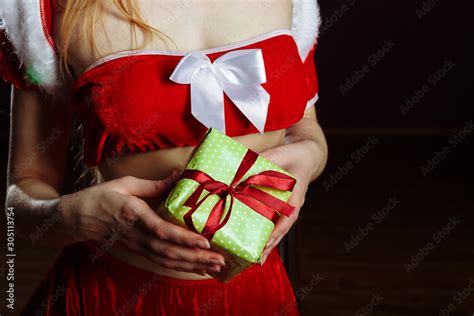 Beautiful Redhead Strip Tease Girl In A Dress And Santa Hat Is Standing