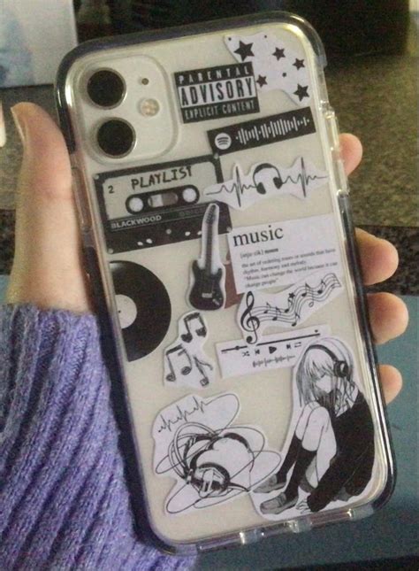 Someone Is Holding Up Their Phone Case With Stickers On It And There Are Other Things In Front