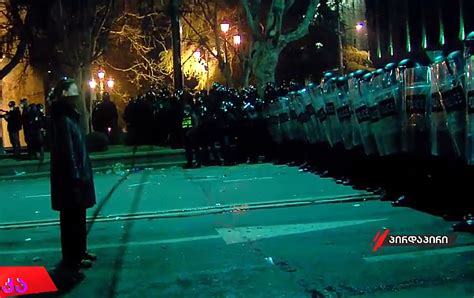 დღის კადრი აქციიდან გოგონა შეიარაღებული სპეცრაზმის პირისპირ უშიშრად