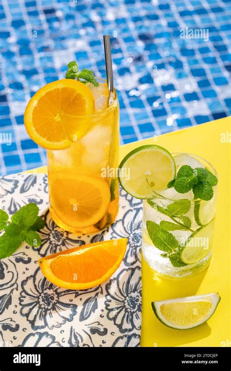 Orange Juice Cocktail Screwdriver And Mojito On Tiled Swimming Pool